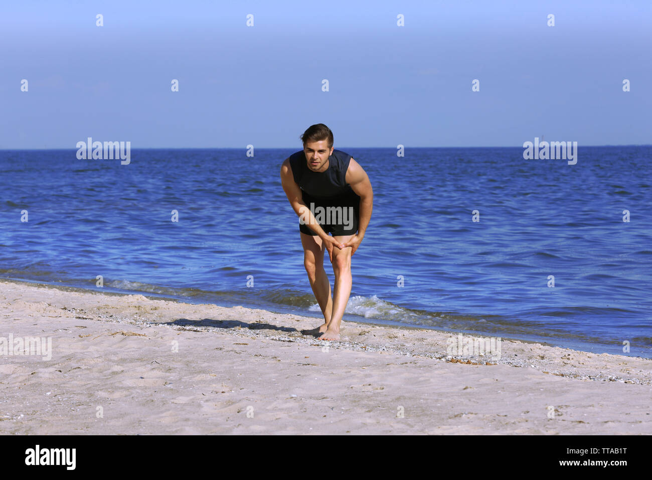 Young man sporty doing exercise on beach Stock Photo - Alamy