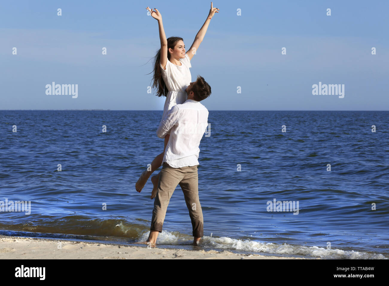 Young couple hugging on beach Stock Photo - Alamy