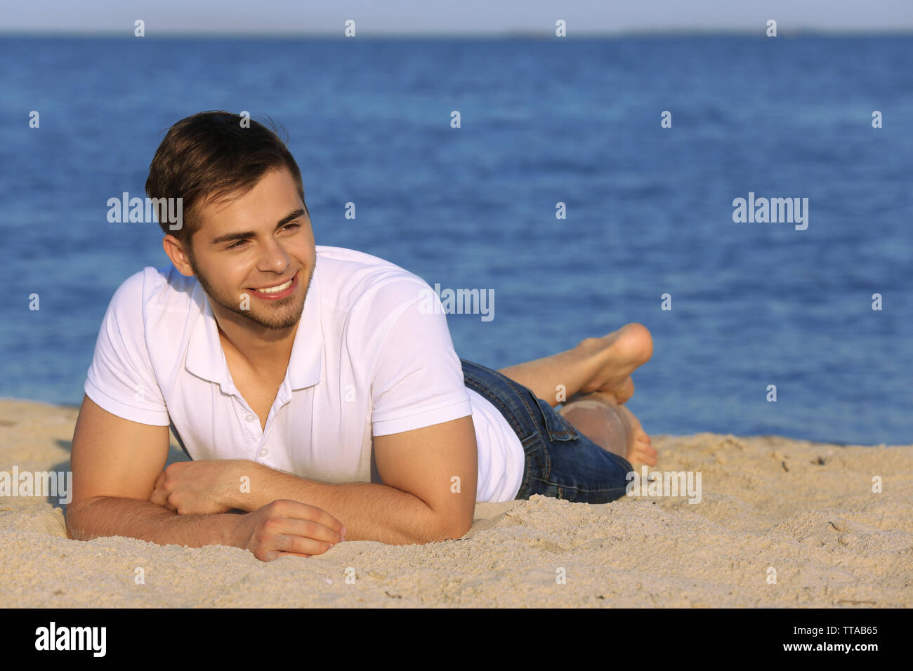 Pretty guy lying on beach Stock Photo - Alamy