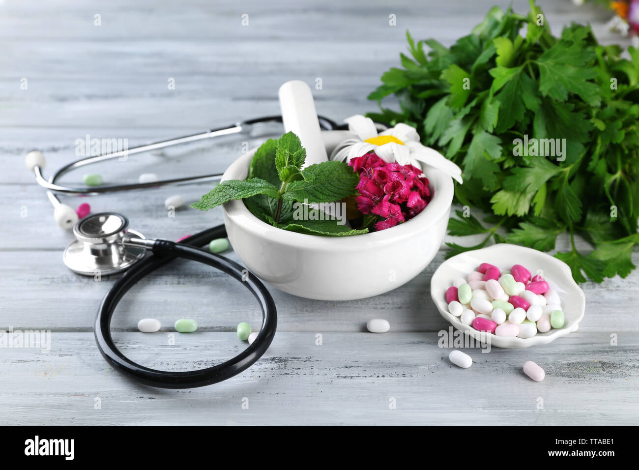 Alternative medicine herbs and stethoscope on wooden table background ...