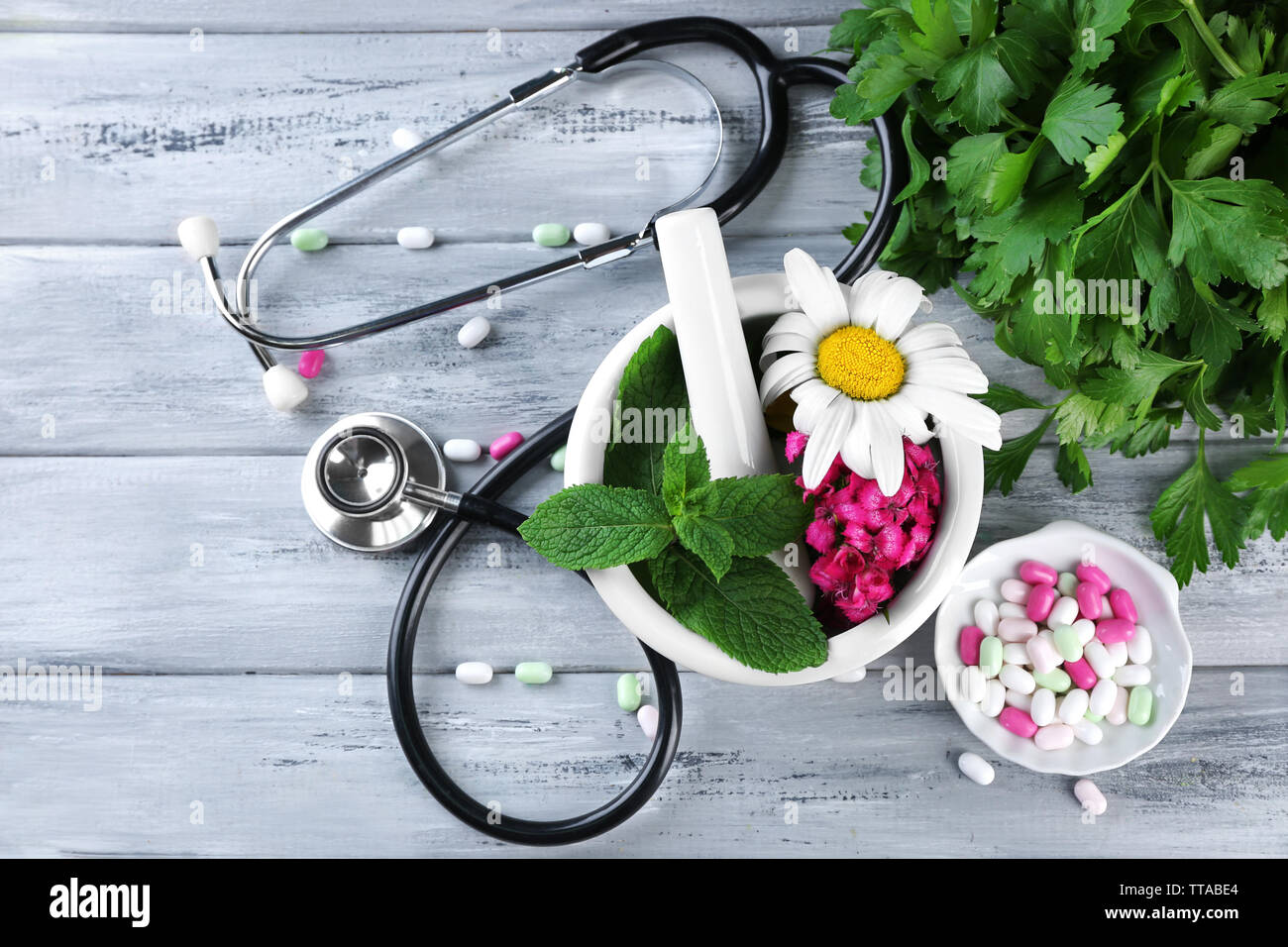 Alternative medicine herbs and stethoscope on wooden table background ...