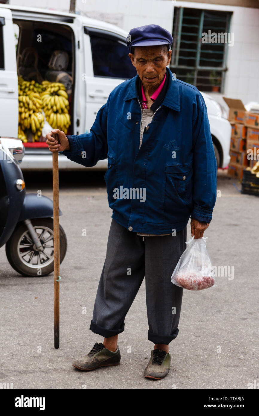 Poor man strolls street in Kunming, China Stock Photo - Alamy