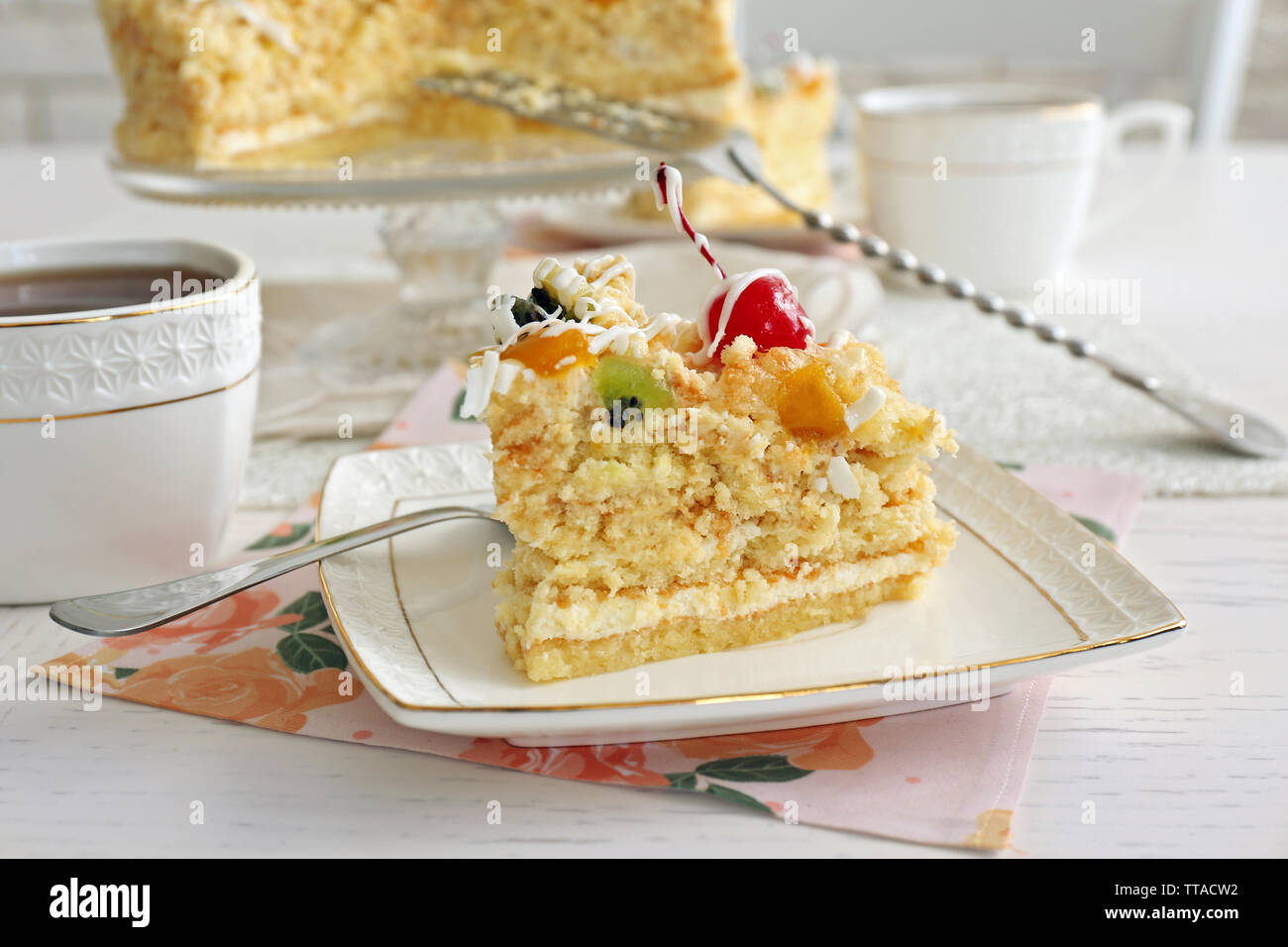 Peace of tasty Butter cake on plate, tea cups on color wooden ...
