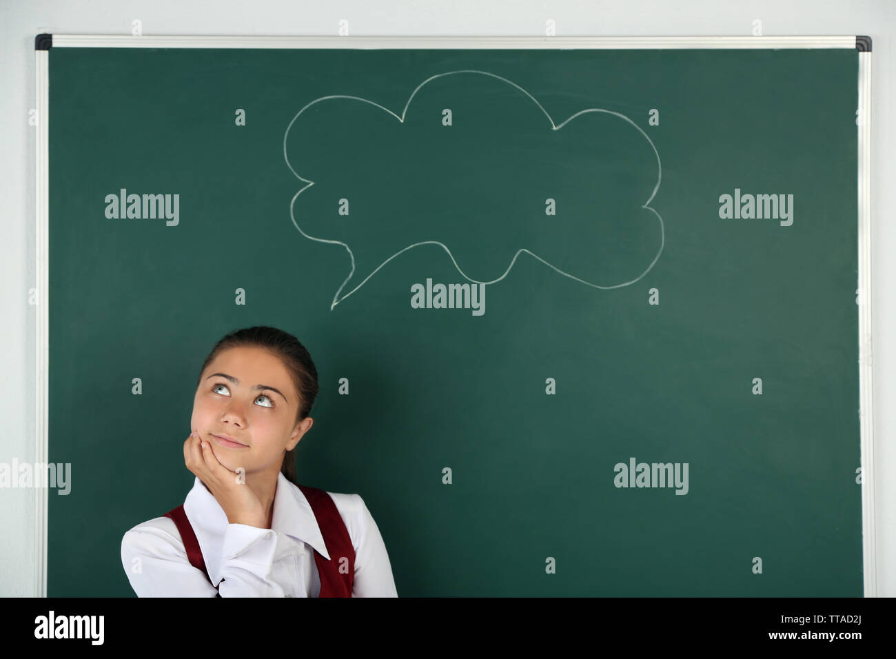 Beautiful little girl standing near blackboard Stock Photo - Alamy