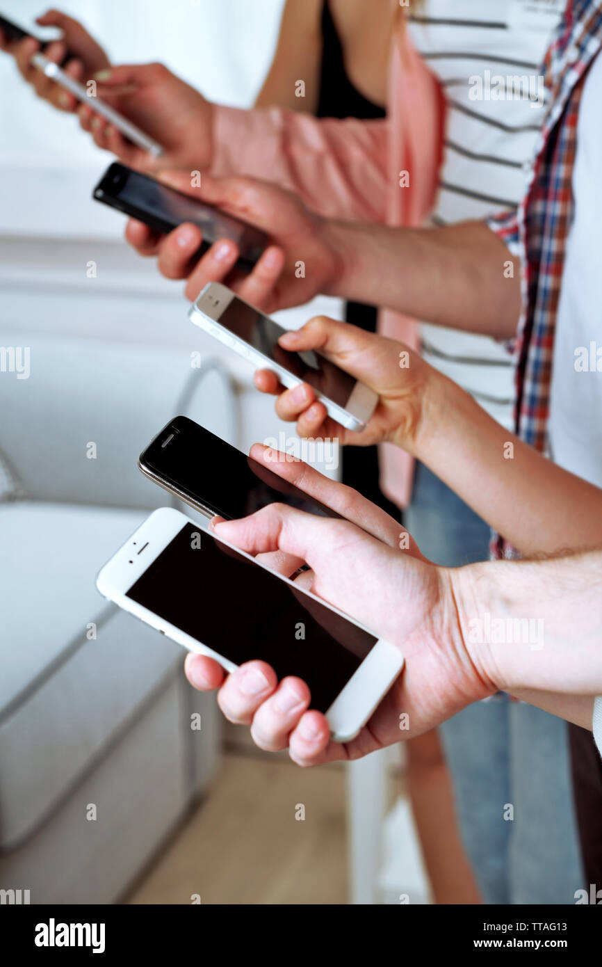 Many hands holding mobile phones close up Stock Photo - Alamy