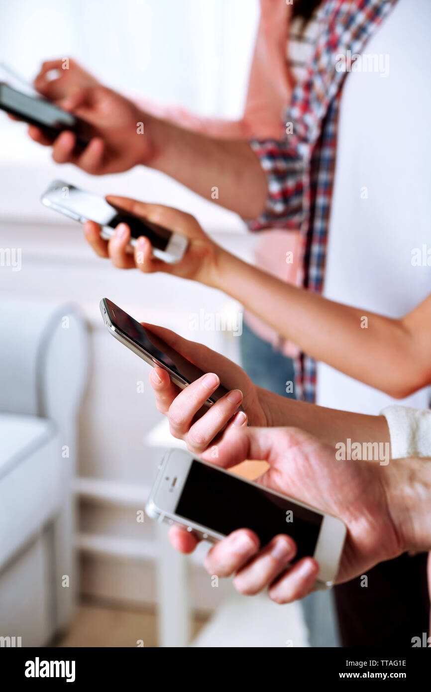 Many hands holding mobile phones close up Stock Photo - Alamy