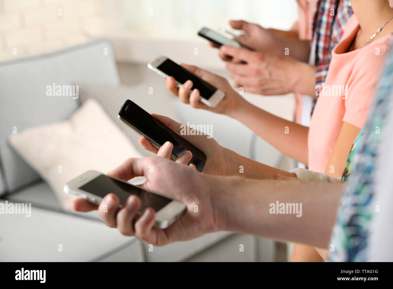 Many hands holding mobile phones close up Stock Photo - Alamy