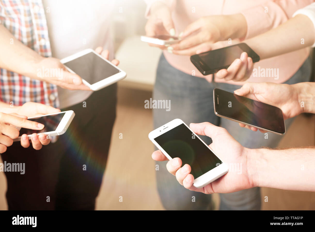 Many hands holding mobile phones close up Stock Photo - Alamy