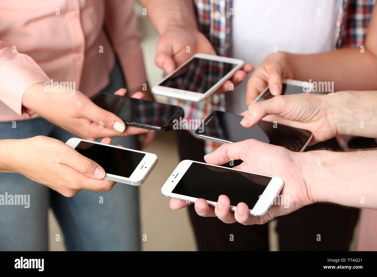 Many hands holding mobile phones close up Stock Photo - Alamy