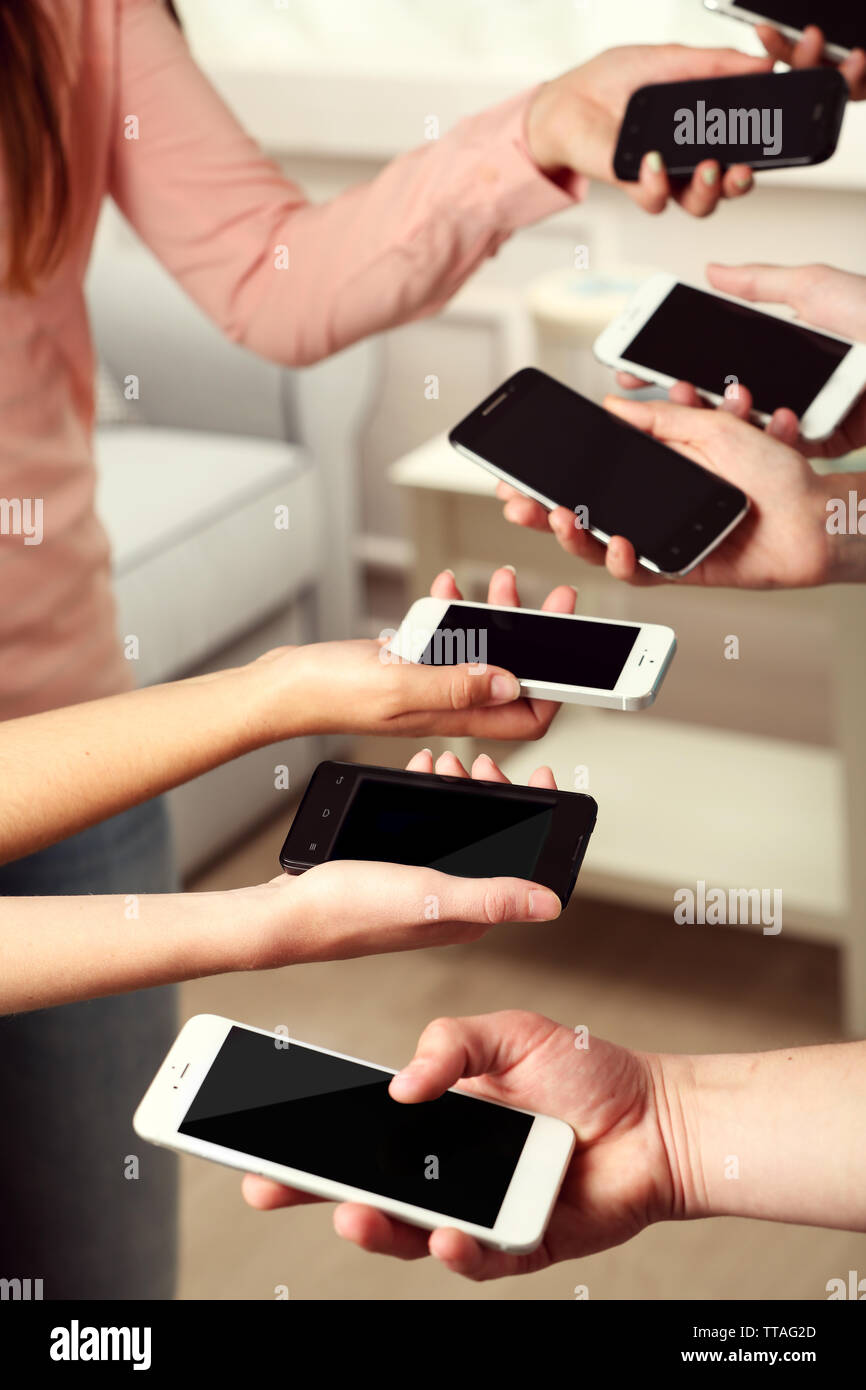 Many hands holding mobile phones close up Stock Photo - Alamy