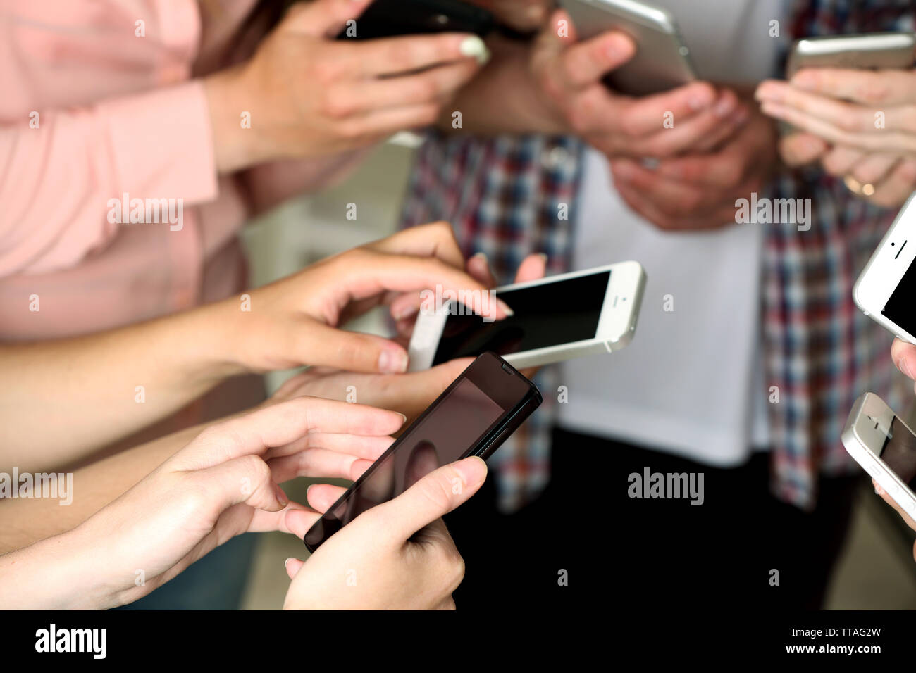 Many hands holding mobile phones close up Stock Photo - Alamy