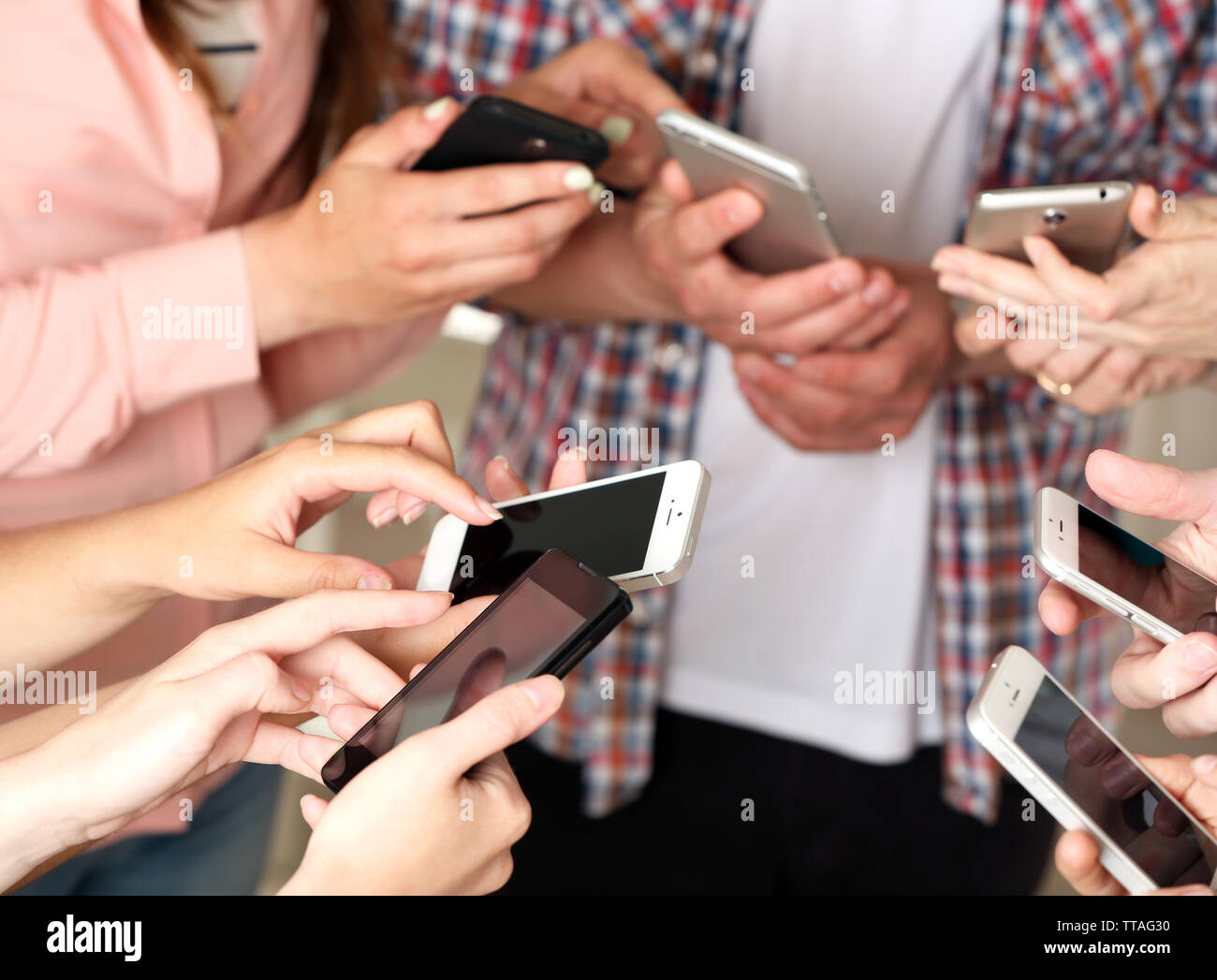 Many hands holding mobile phones close up Stock Photo - Alamy