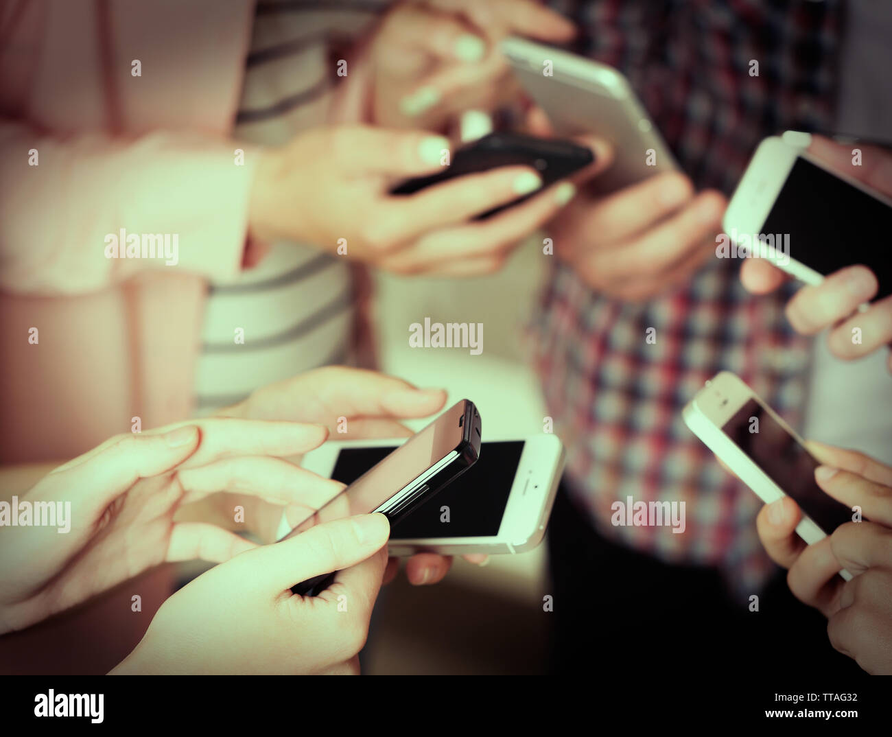 Many hands holding mobile phones close up Stock Photo - Alamy