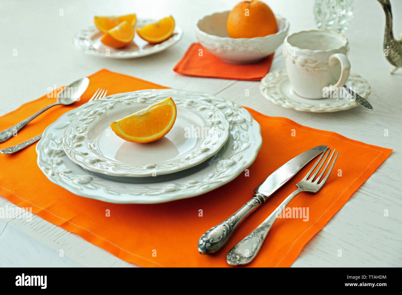 Table setting with orange napkin Stock Photo - Alamy