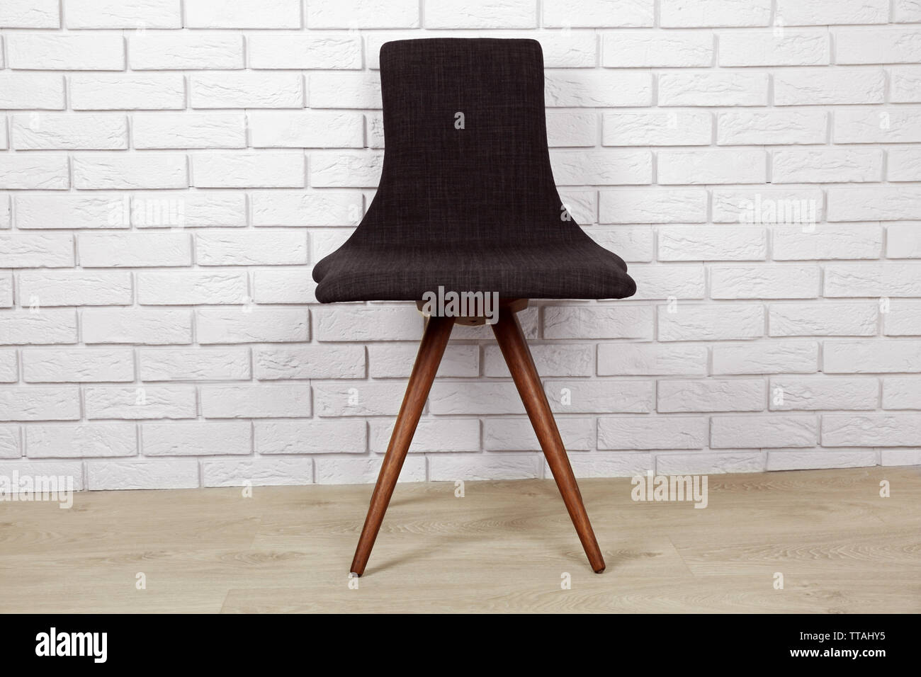 Modern chair on brick wall background Stock Photo - Alamy