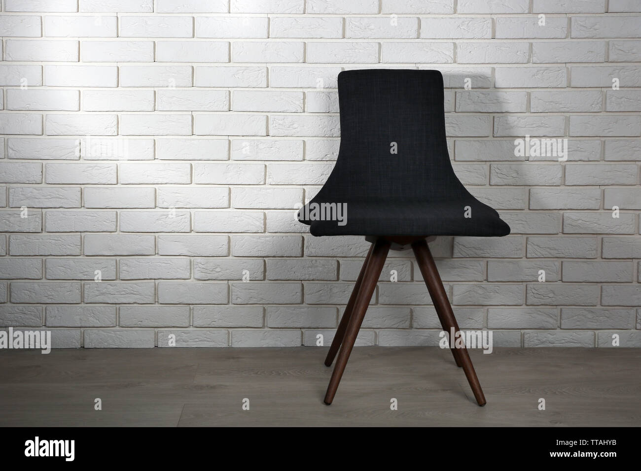 Modern chair on brick wall background Stock Photo - Alamy
