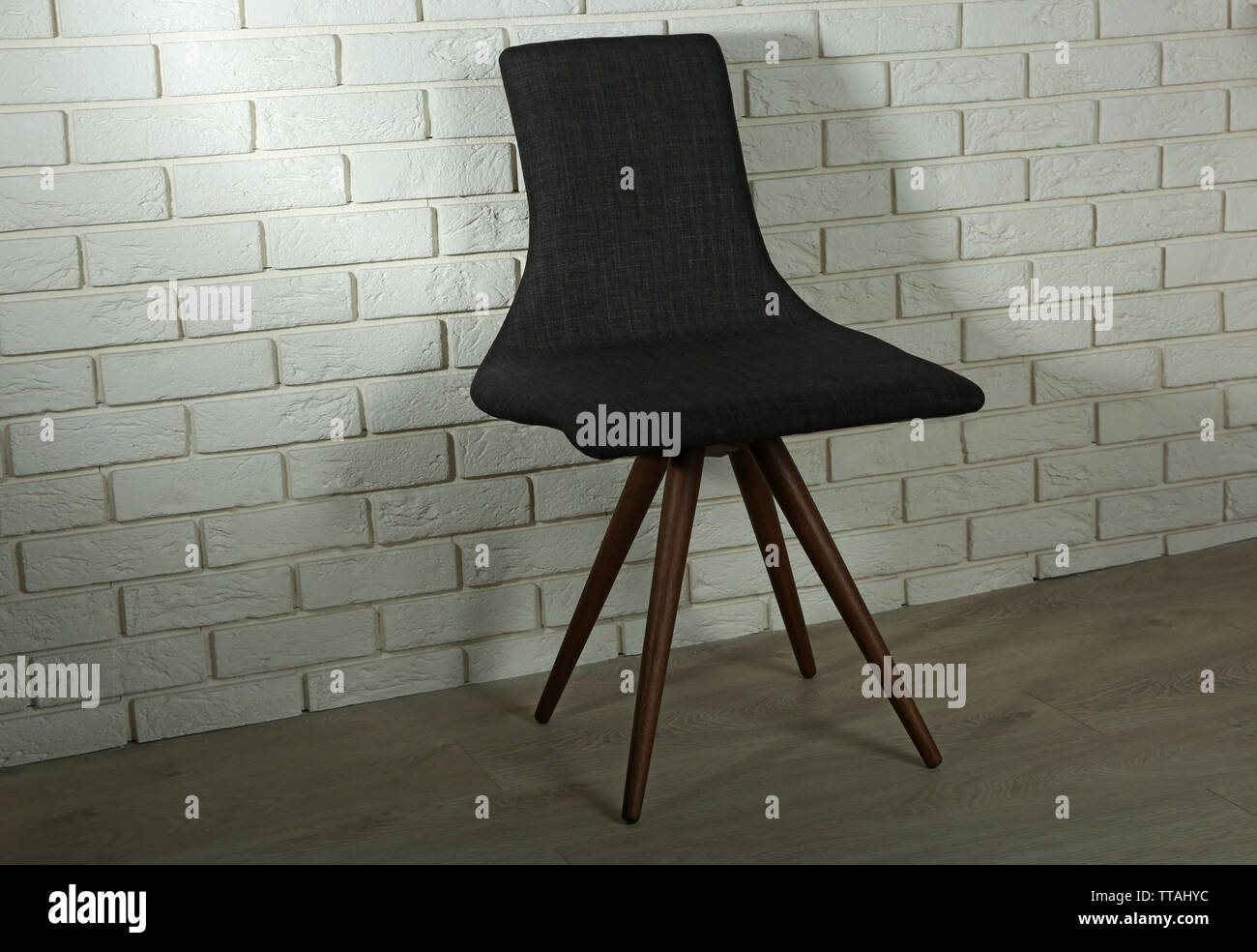 Modern chair on brick wall background Stock Photo - Alamy