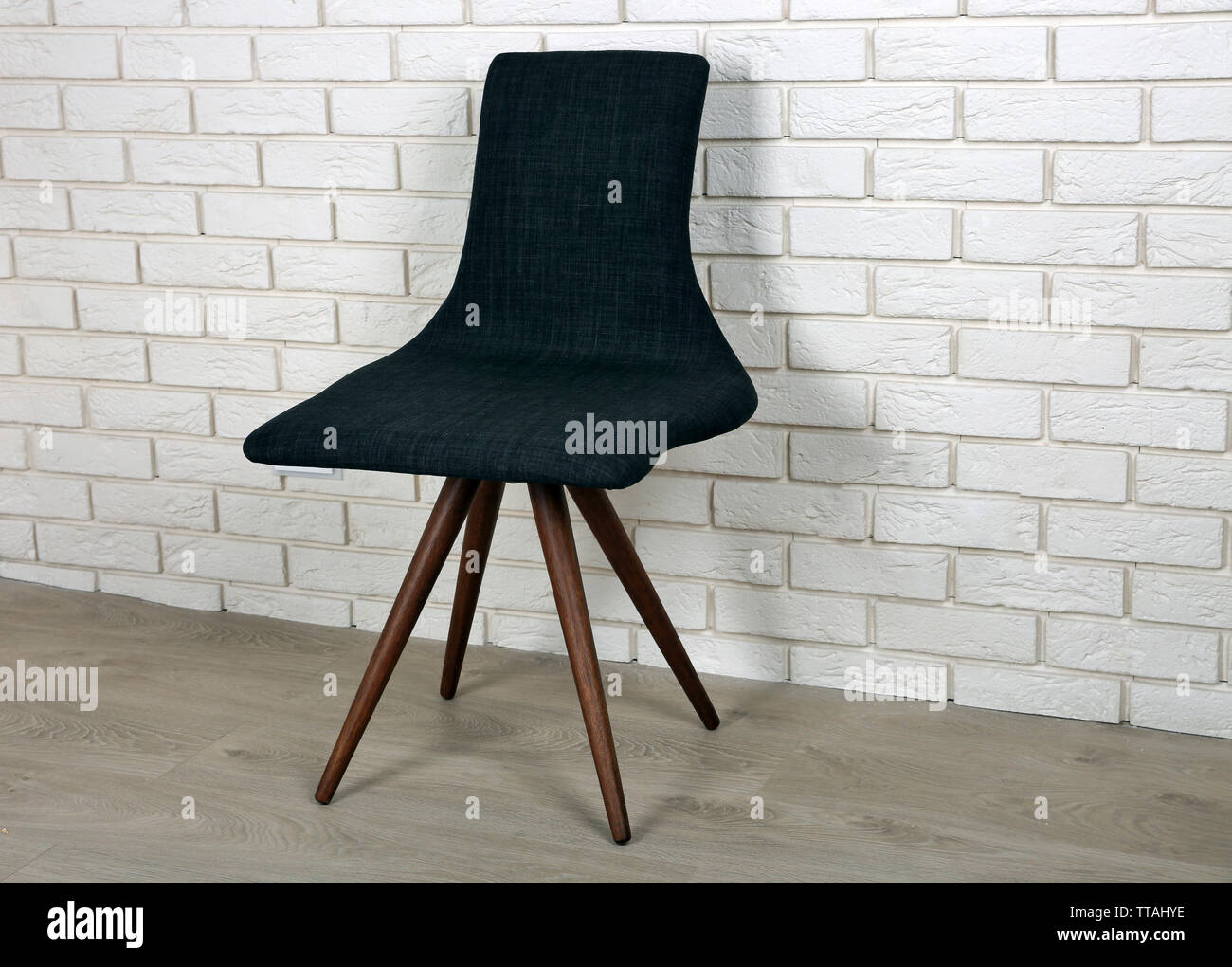 Modern chair on brick wall background Stock Photo - Alamy