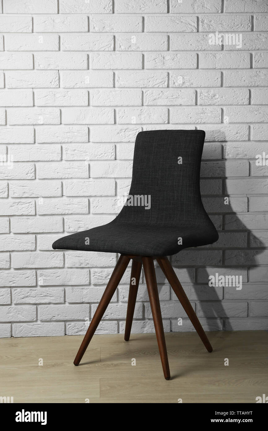 Modern chair on brick wall background Stock Photo - Alamy