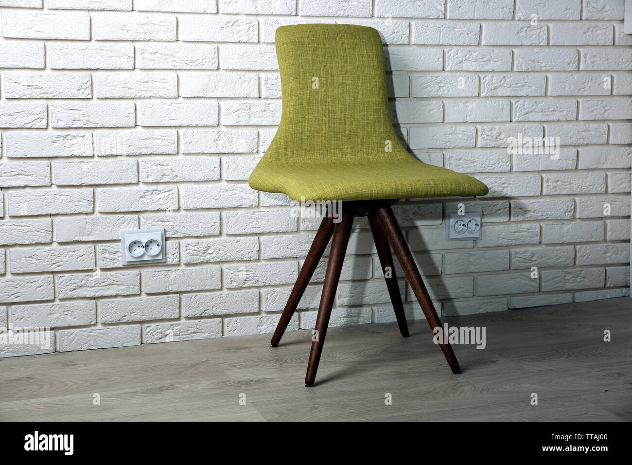 Modern chair on brick wall background Stock Photo - Alamy