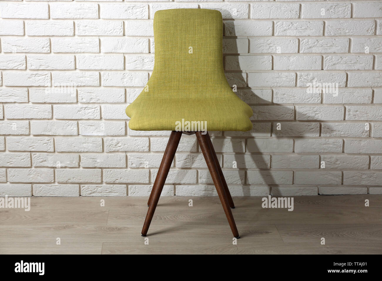 Modern chair on brick wall background Stock Photo - Alamy