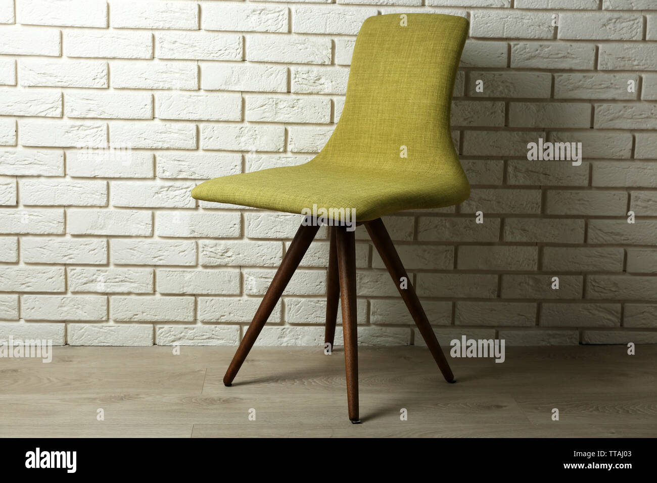 Modern chair on brick wall background Stock Photo - Alamy