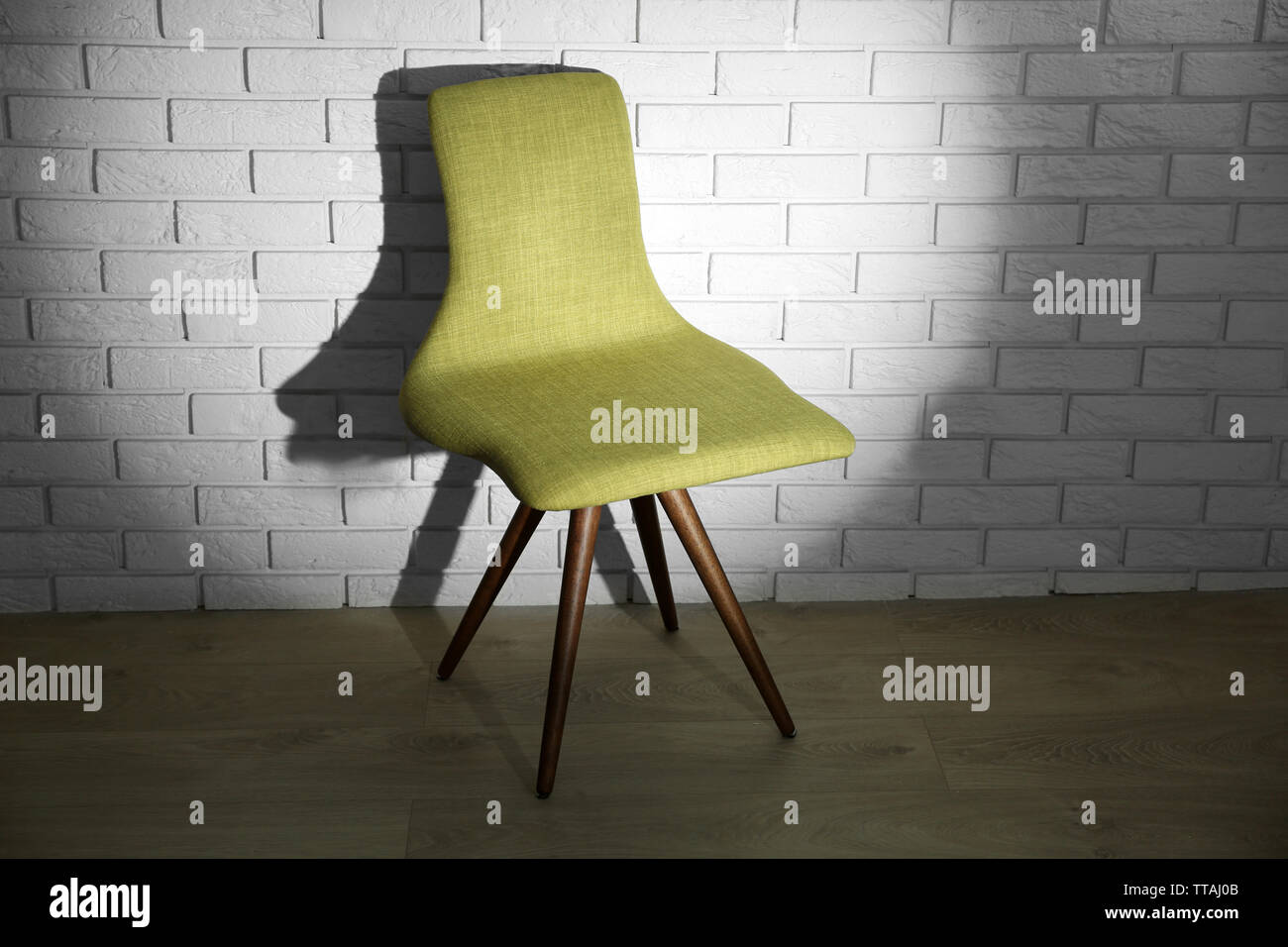 Modern chair on brick wall background Stock Photo - Alamy