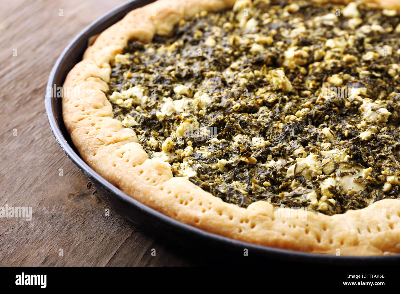Open pie with spinach on wooden table close up Stock Photo - Alamy