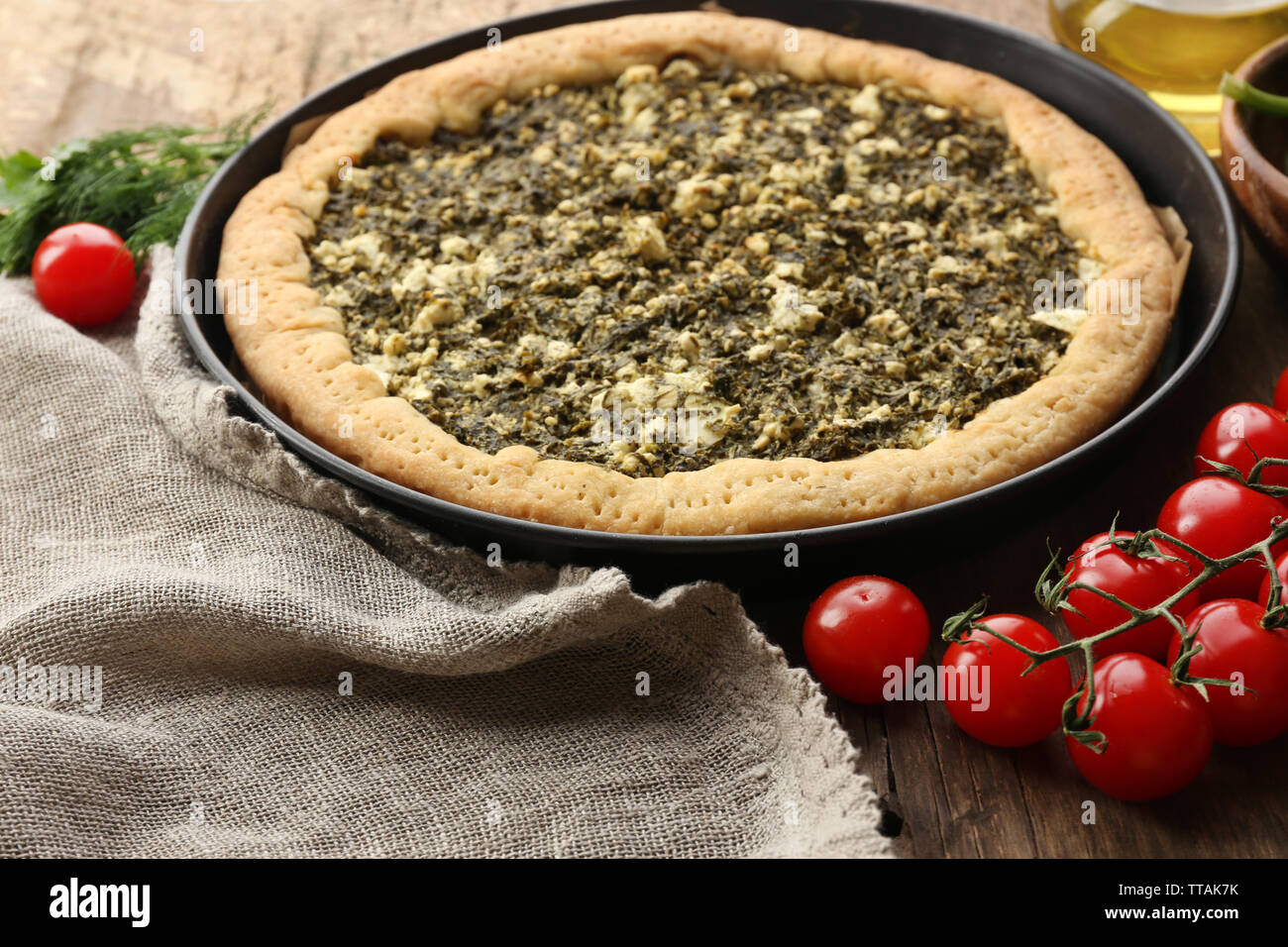 Open pie with spinach and tomato cherry on table close up Stock Photo ...