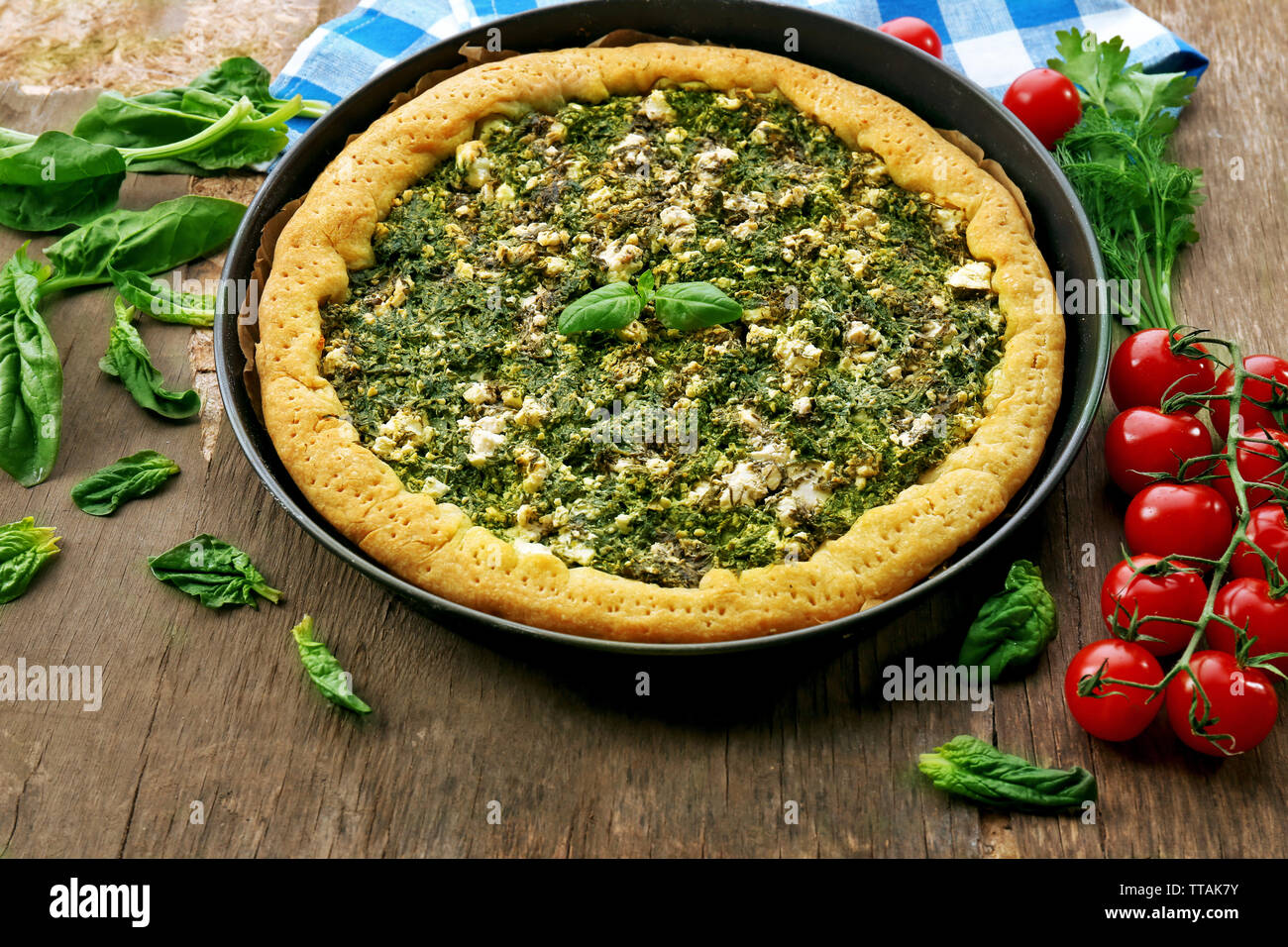 Open pie with spinach and tomato cherry on table close up Stock Photo ...