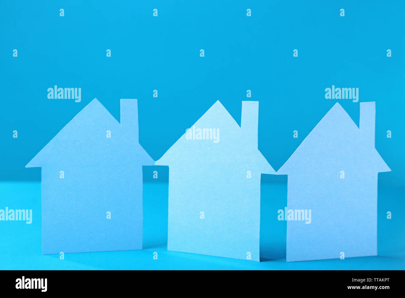 Color paper houses on turquoise background Stock Photo - Alamy