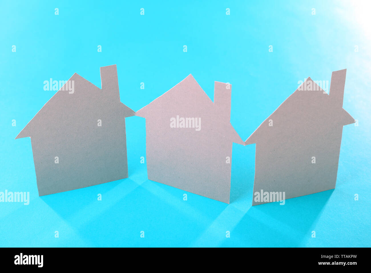 Color paper houses on turquoise background Stock Photo - Alamy