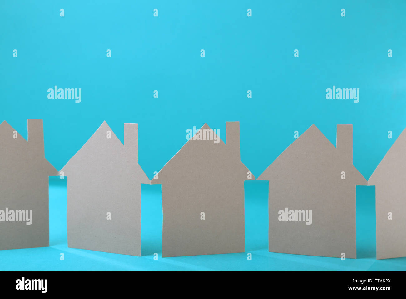 Color paper houses on turquoise background Stock Photo - Alamy