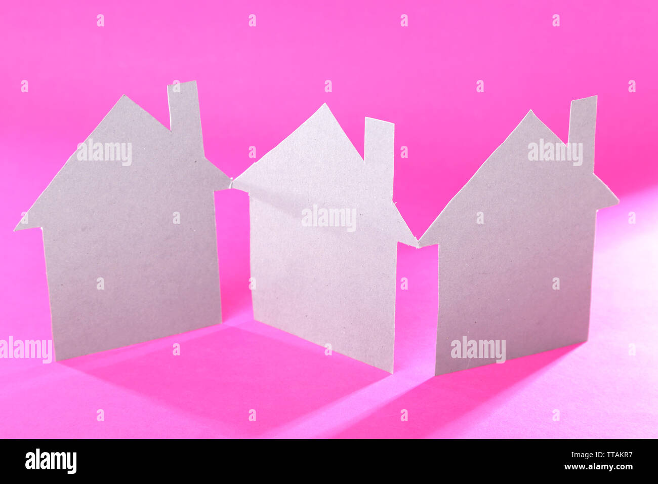 Color paper houses on pink background Stock Photo - Alamy