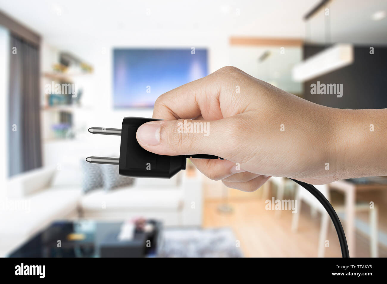 Human hand hold black electric plug for energy saving Stock Photo - Alamy