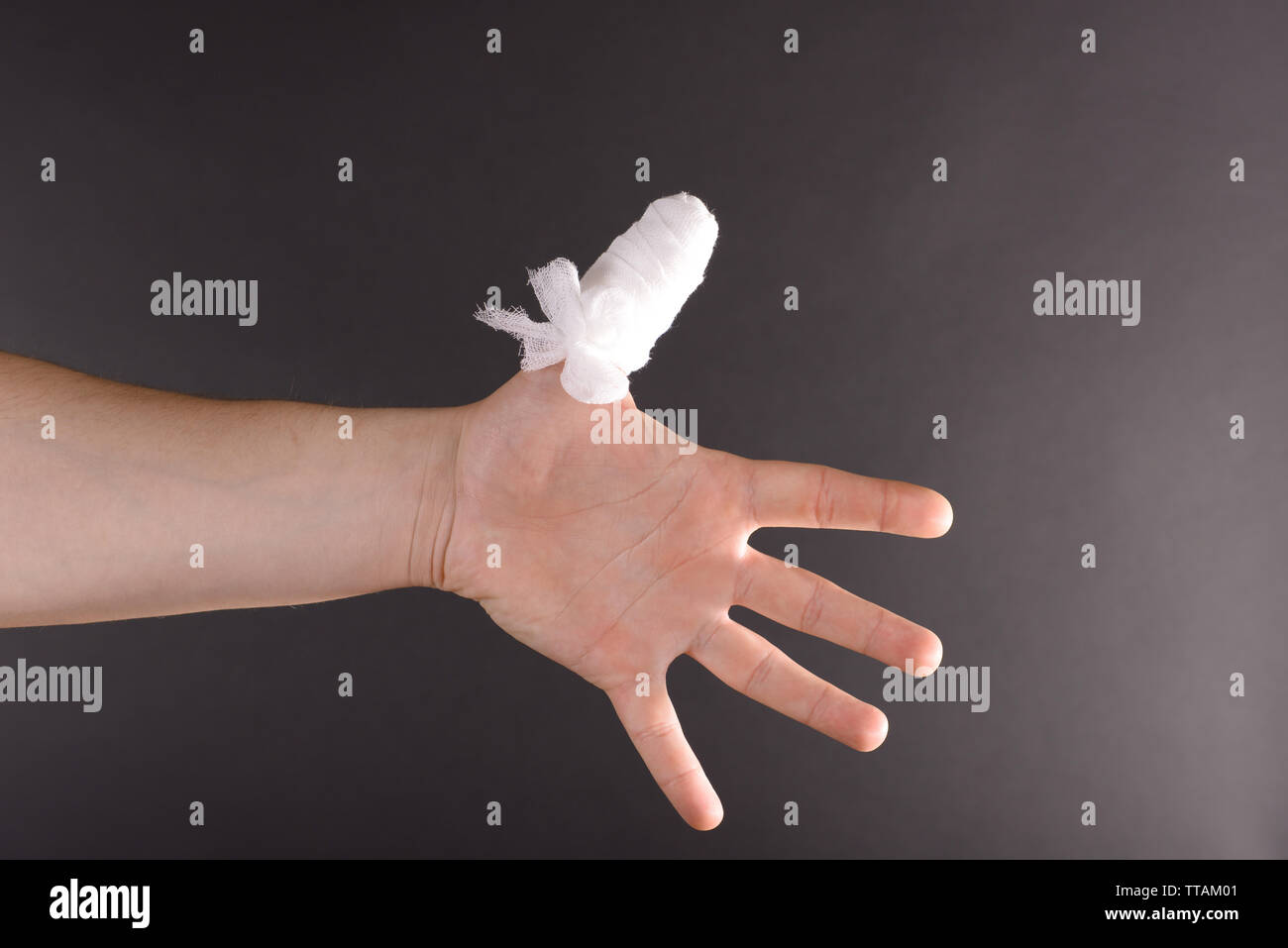Injured bandaged finger on dark background Stock Photo - Alamy