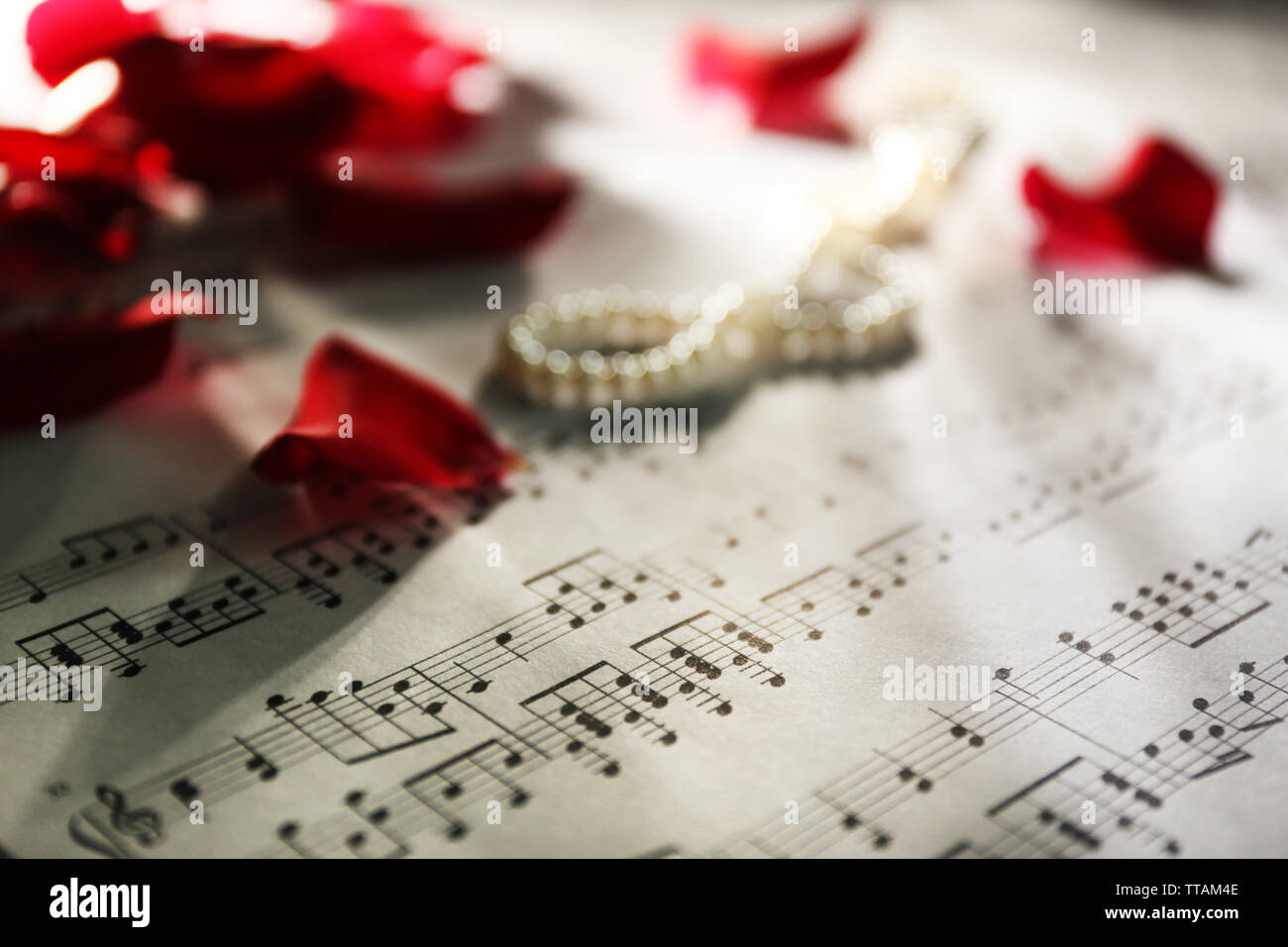 Beautiful rose petals with pearls on music sheets background Stock ...