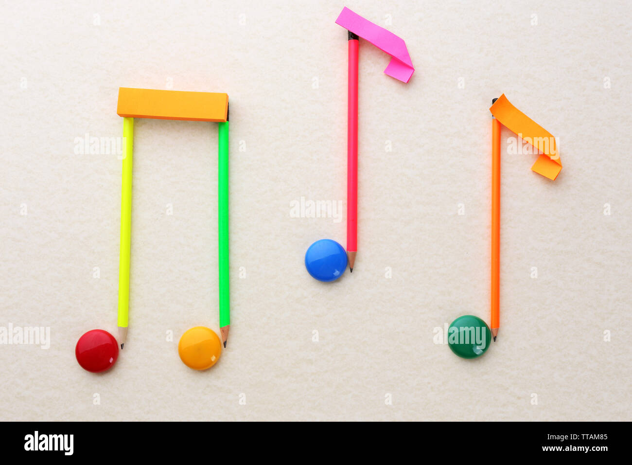 Creative music notes of colorful pins, sticks and crayons on light ...