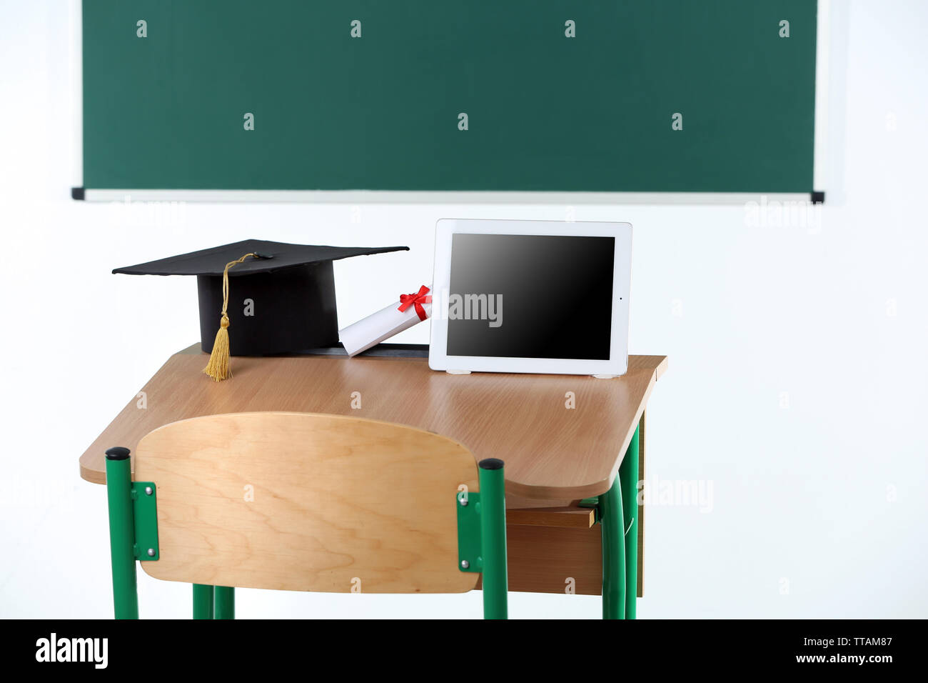 School desk with tablet, master hat and diploma in classroom Stock ...