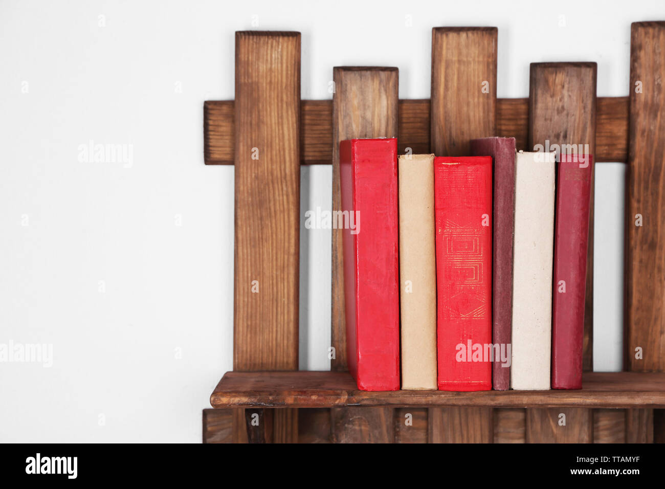 Wooden shelf with books on wall background Stock Photo - Alamy