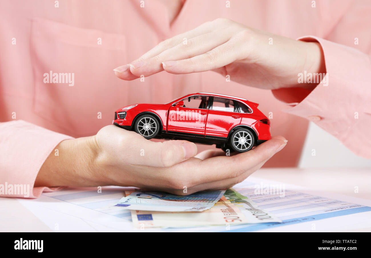 Hands and toy car. Protection of car concept Stock Photo - Alamy