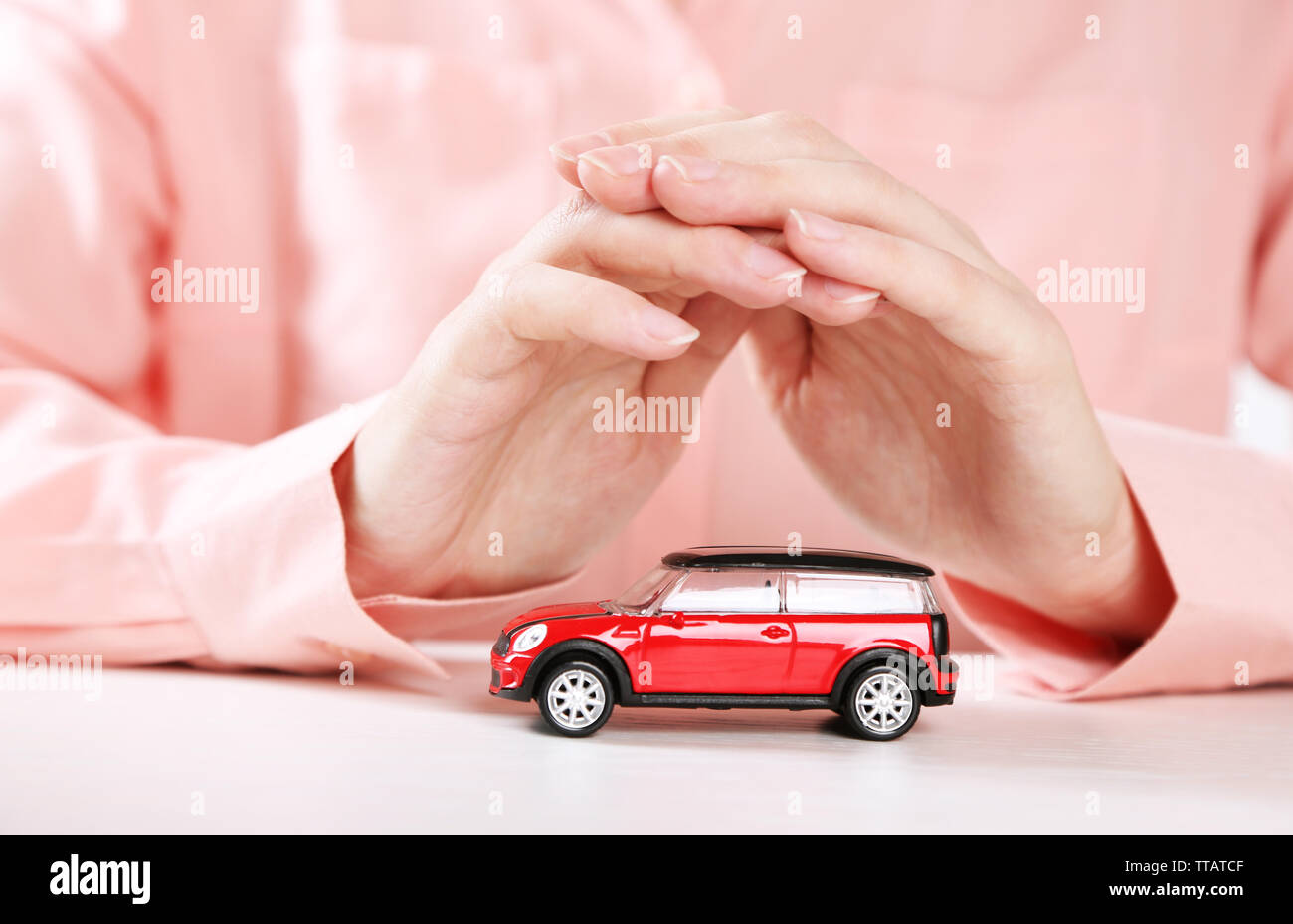 Hands and toy car. Protection of car concept Stock Photo - Alamy