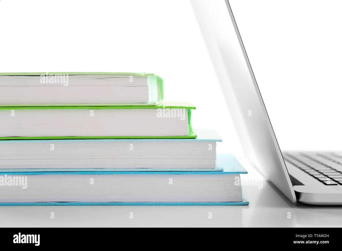 Stack of books with laptop close up Stock Photo - Alamy