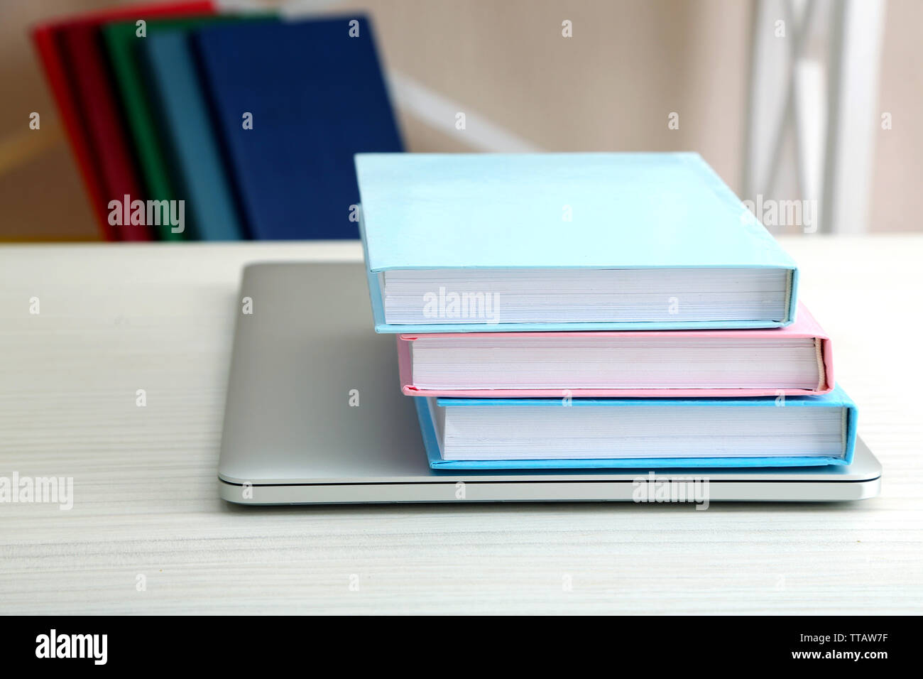 Stack of books with laptop on table close up Stock Photo - Alamy
