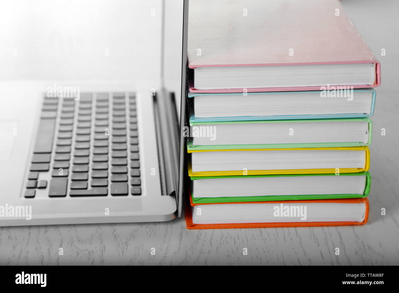 Stack of books with laptop on table close up Stock Photo - Alamy