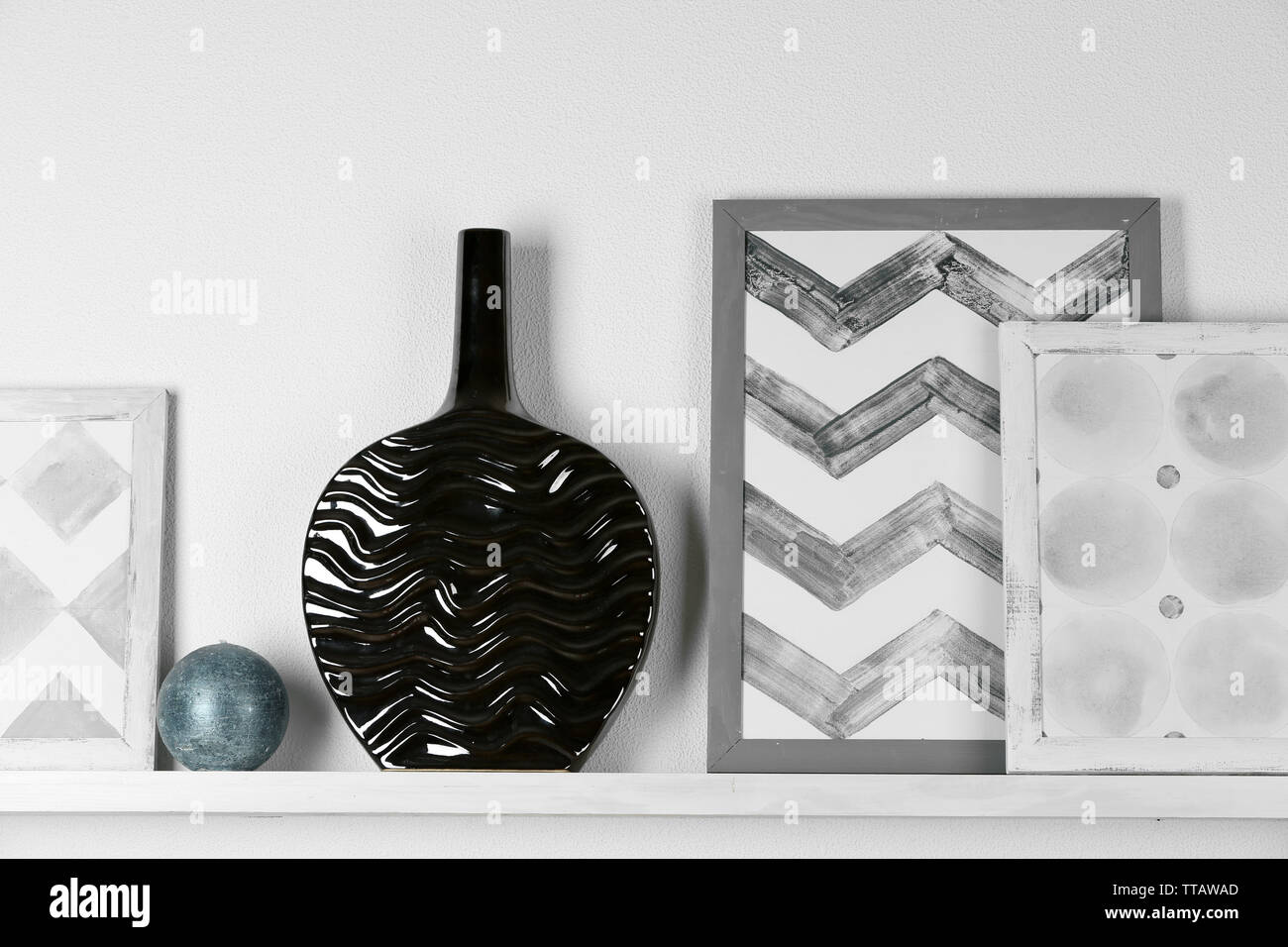 Modern vase with picture on shelf in room Stock Photo - Alamy