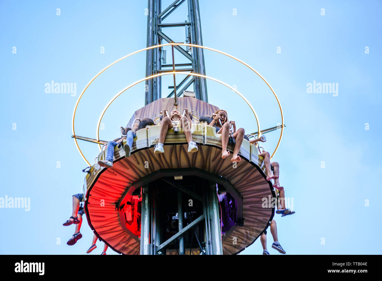 Young friends have fun in the park. Happy guys ride on attractions ...