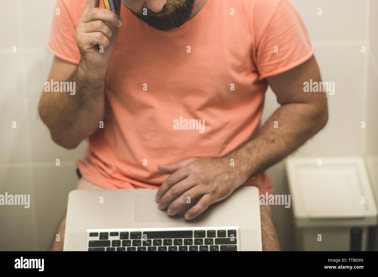 Businessman is working with laptop while sitting on the toilet Stock ...