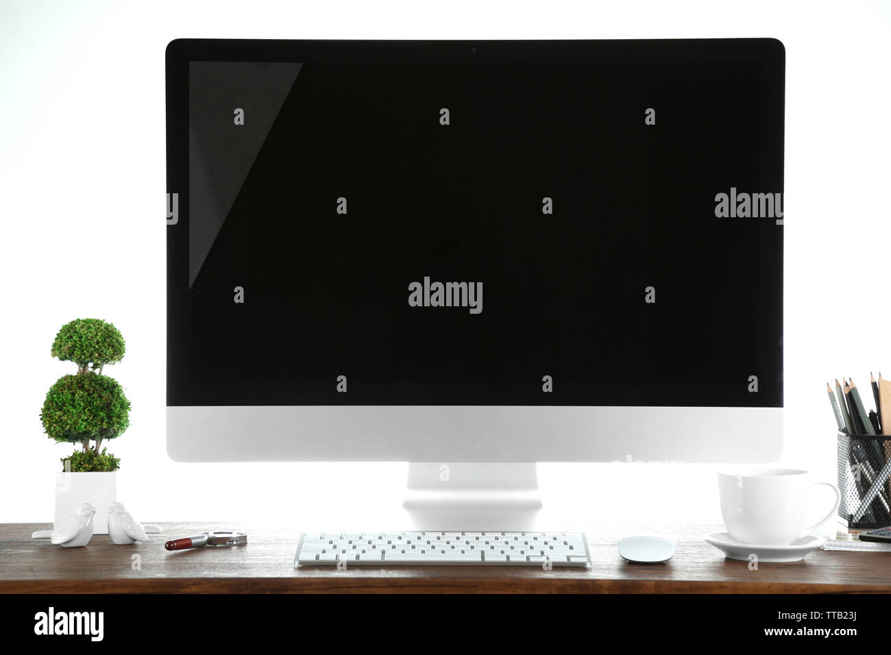 Computer on wooden table with blank white background Stock Photo - Alamy
