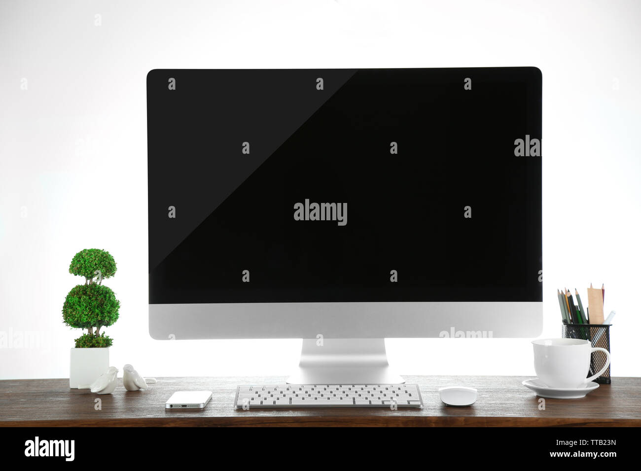 Computer on wooden table with blank white background Stock Photo - Alamy